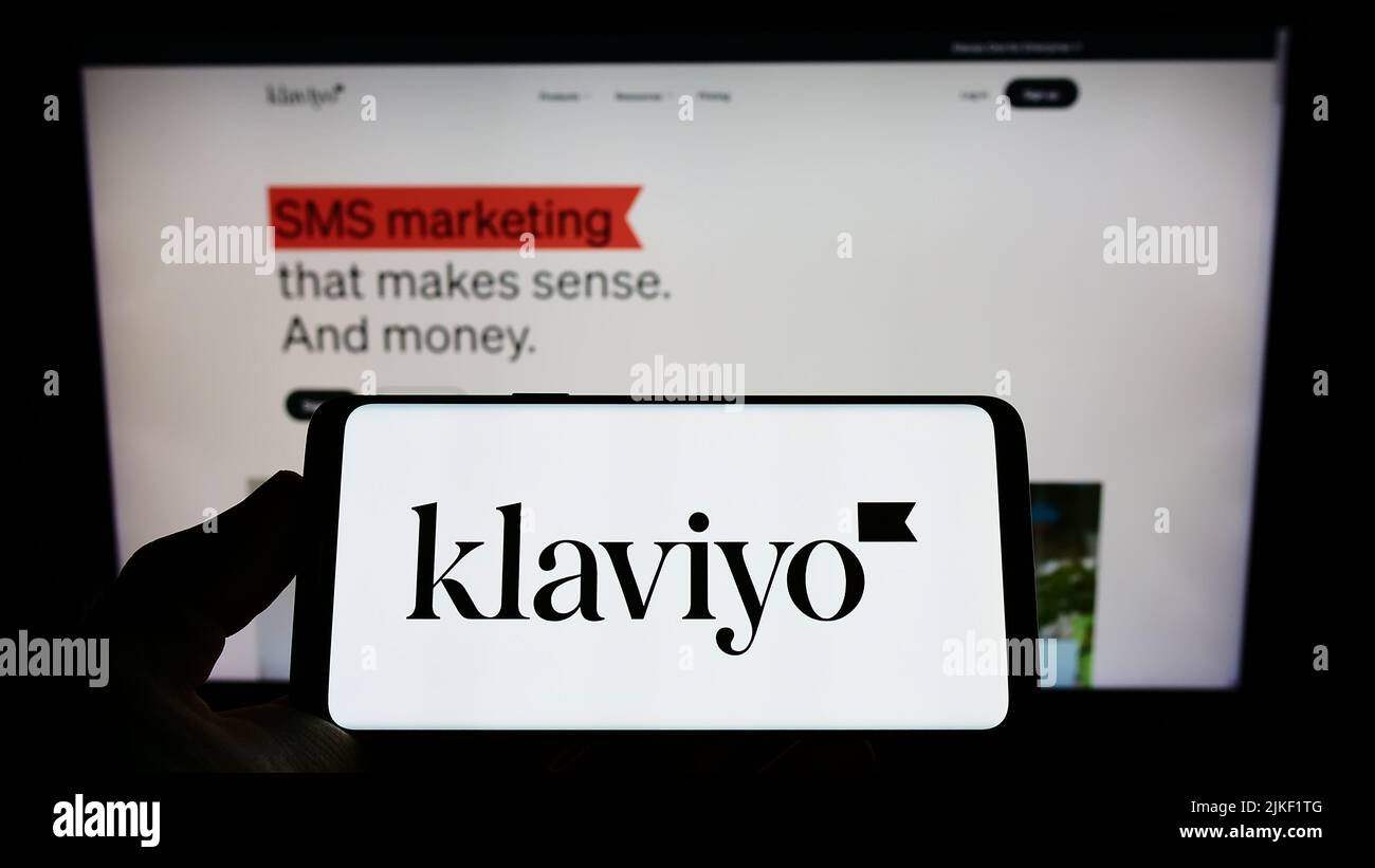 Person holding mobile phone with logo of American marketing software ...