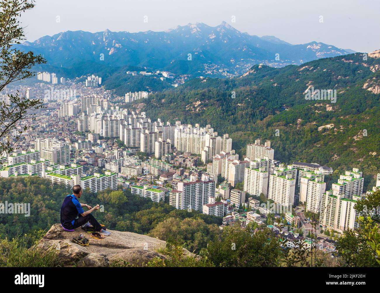 Man Sitting on ledge Above Downtown Seoul Korea having lunch Stock ...