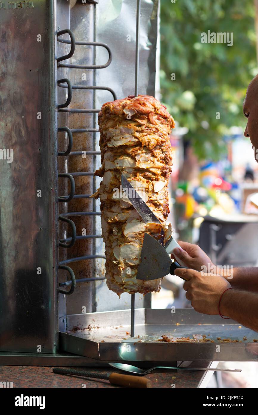 Chef cutting with doner knife Traditional Turkish Doner Kebab meat ...