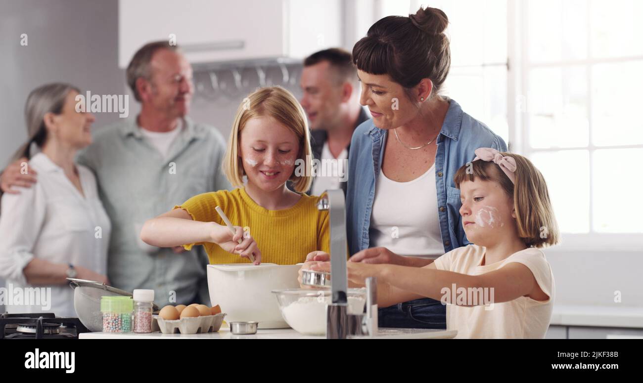 Lets bake something delicious. a family baking together in the kitchen ...