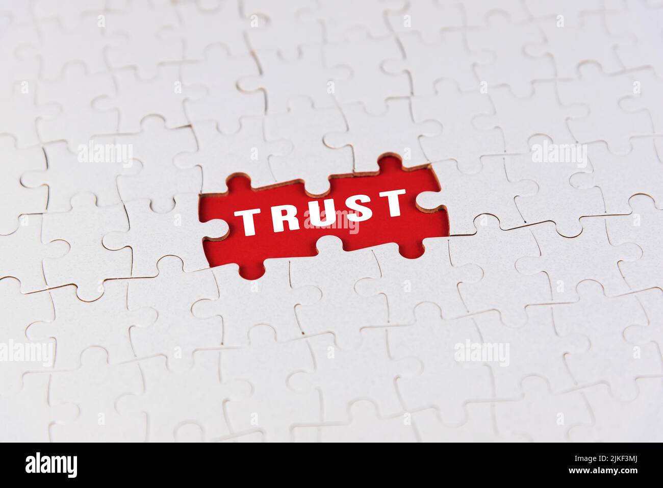 TRUST text on white jigsaw puzzle background with missing piece on red ...