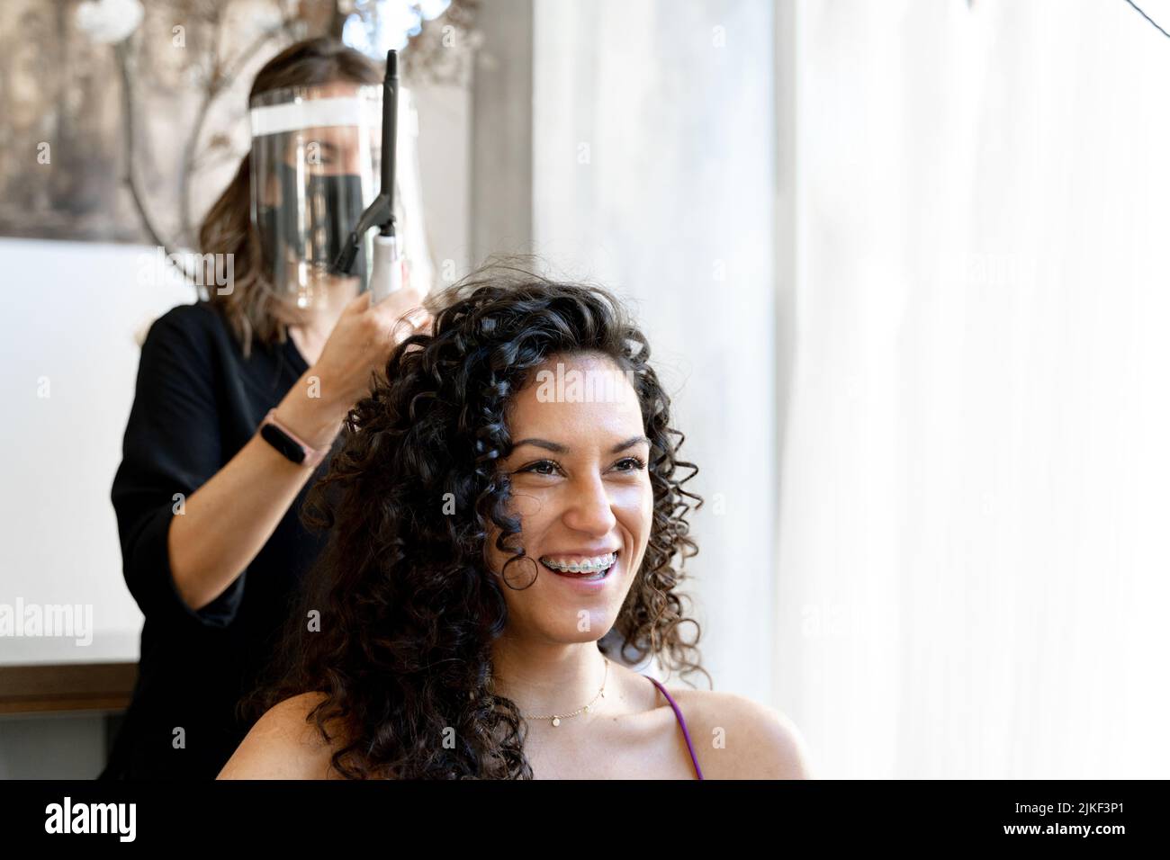 Hairdresser with a plastic protection facial mask for covid and a ...