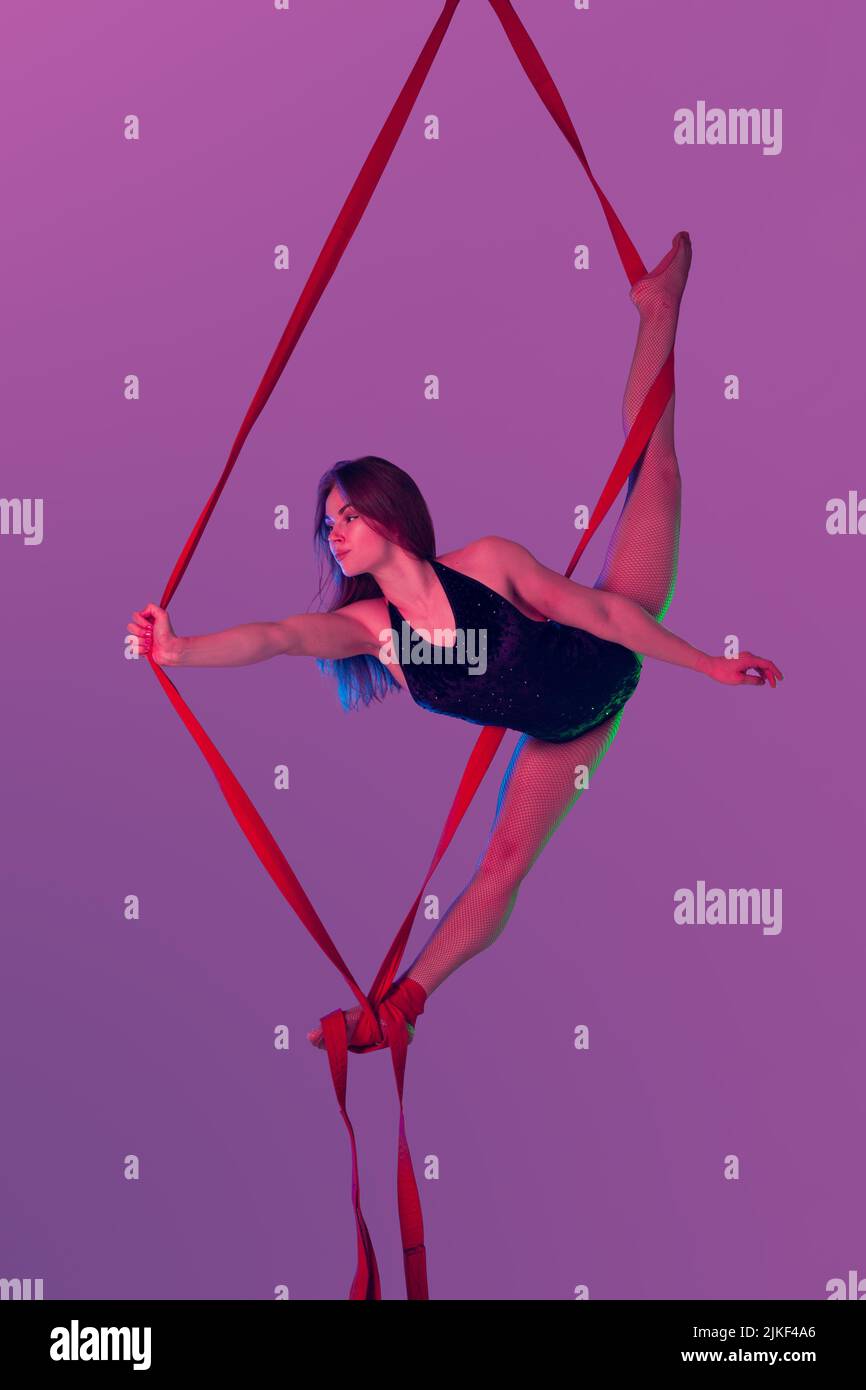 Beautiful girl in a black swimsuit is performing an acrobatic elements ...