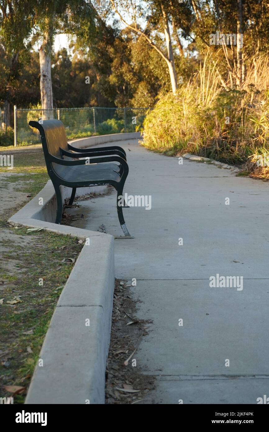 A vertical shot of a metal bench on the paved trail at Kenneth Hahn ...