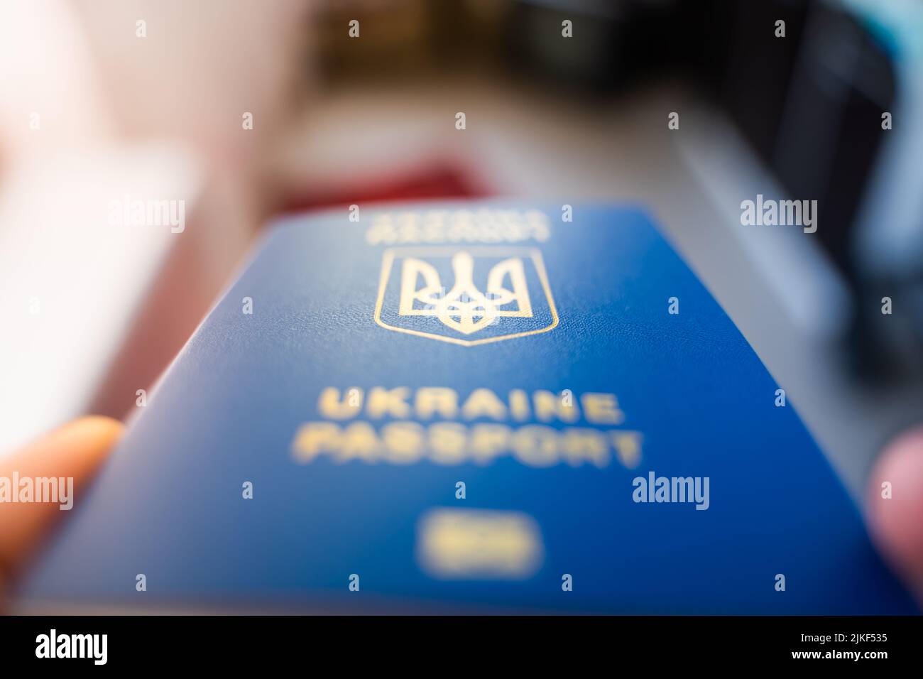 Ukrainian biometric passport in hand close-up on a blurred background ...