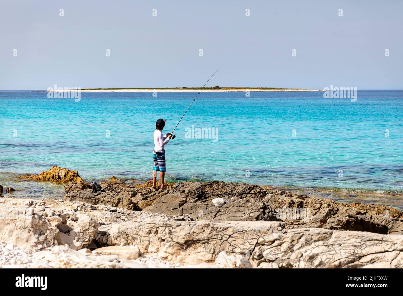 Boy fishing with a fishing rod from a beautiful Veli Zal beach on Dugi ...