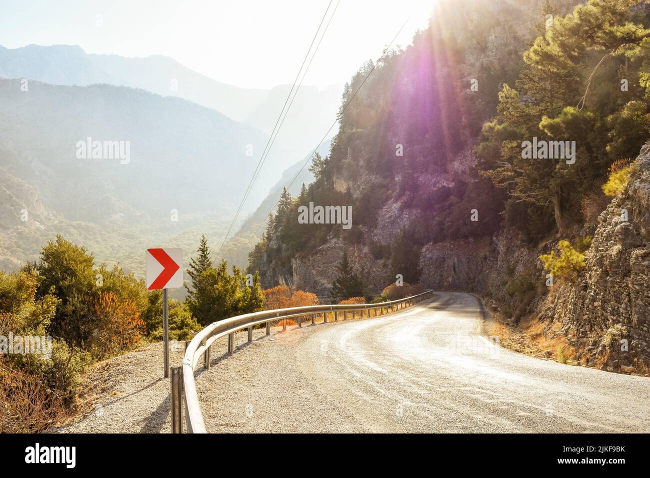 Curved mediterranean asphalt road, bend sign on a hot sunny day ...