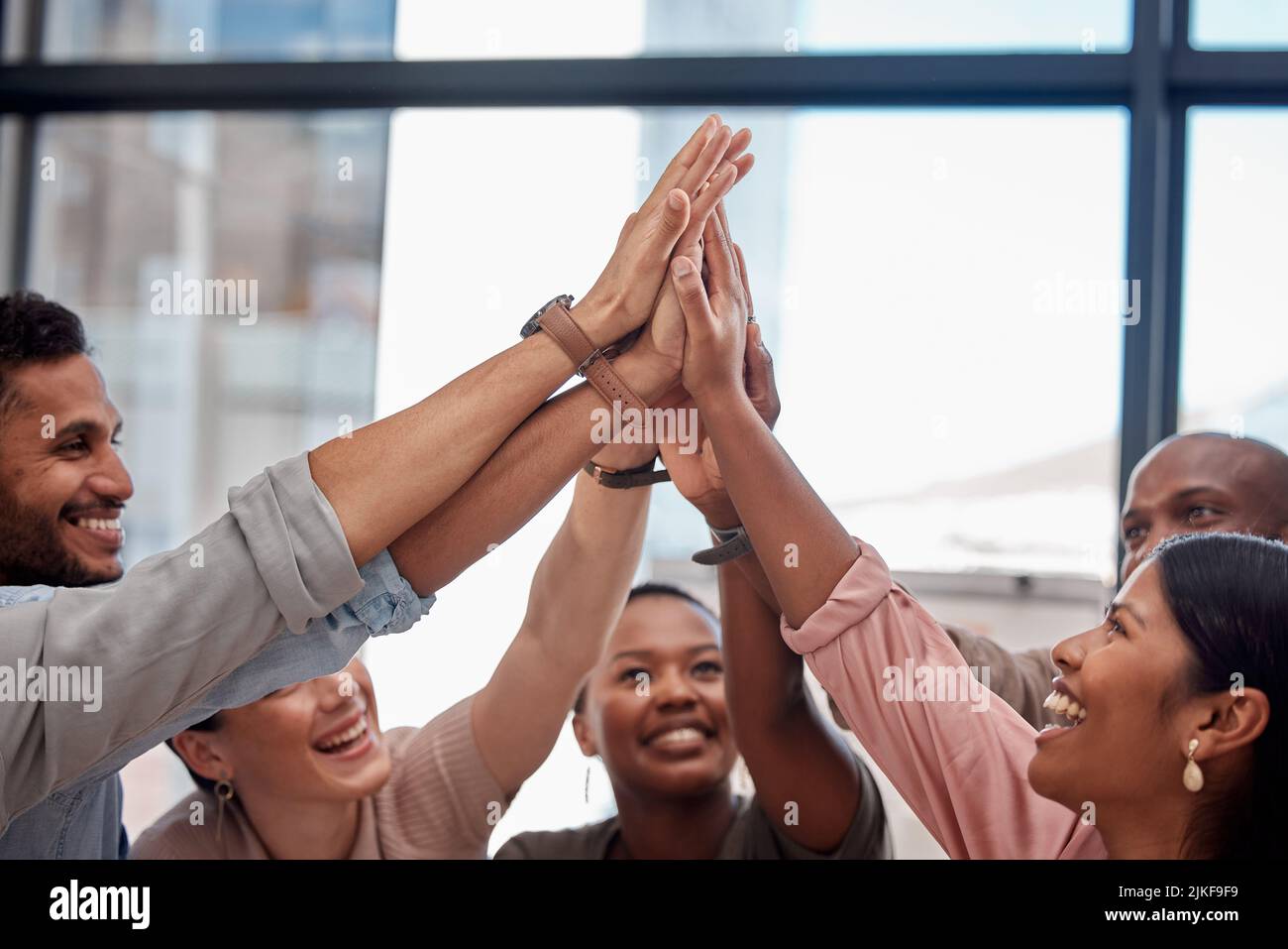 High five for a job well done. a group of young businesspeople giving ...