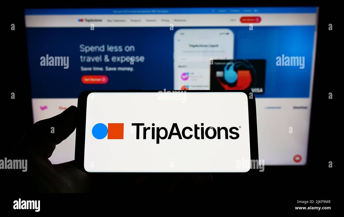 Person holding smartphone with logo of US travel management company ...