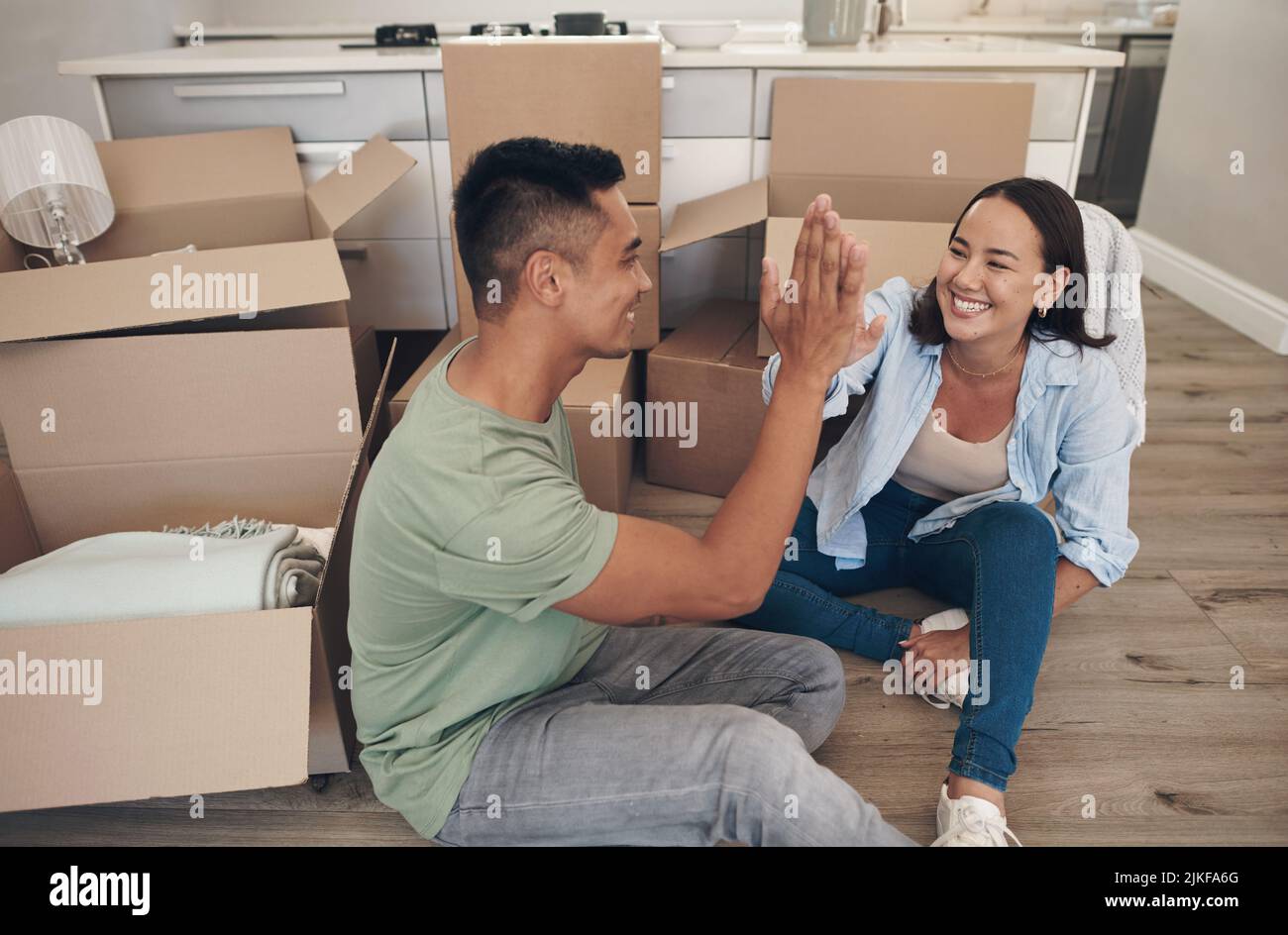 We bought the house of our dreams. a couple sharing a high-five while ...