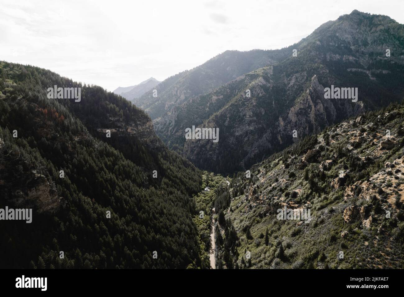 An aerial view of narrow valley surrounded by high mountain forests ...