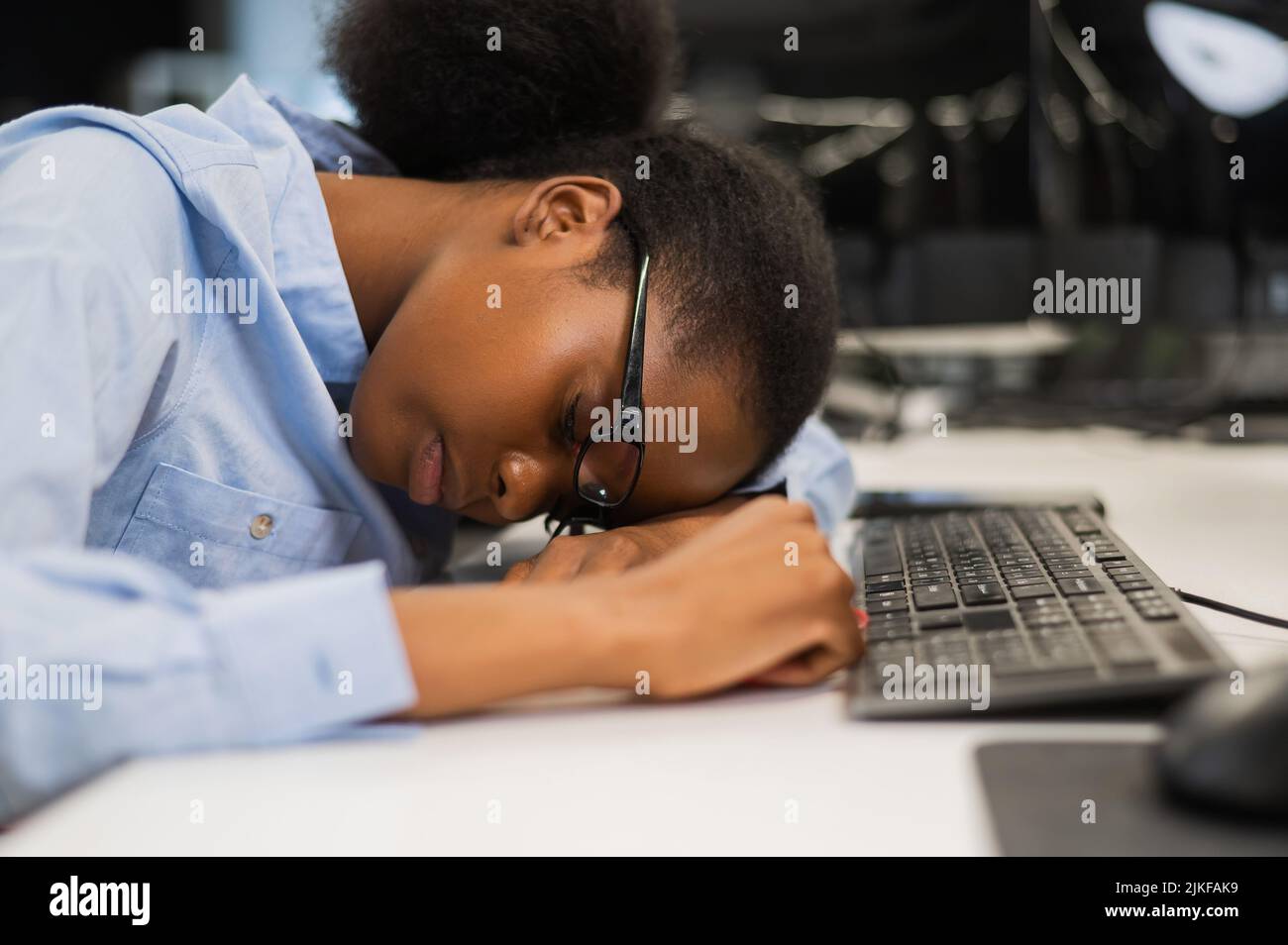 African young woman sleeping at work desk Stock Photo - Alamy