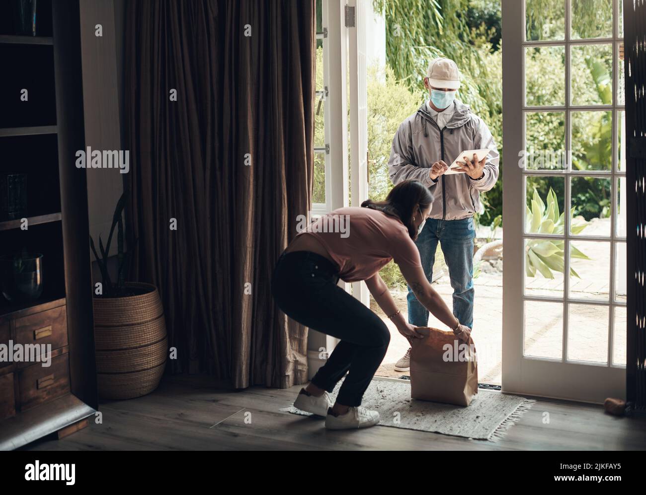 Fast and a speedy delivery. a young man delivering a package to a ...