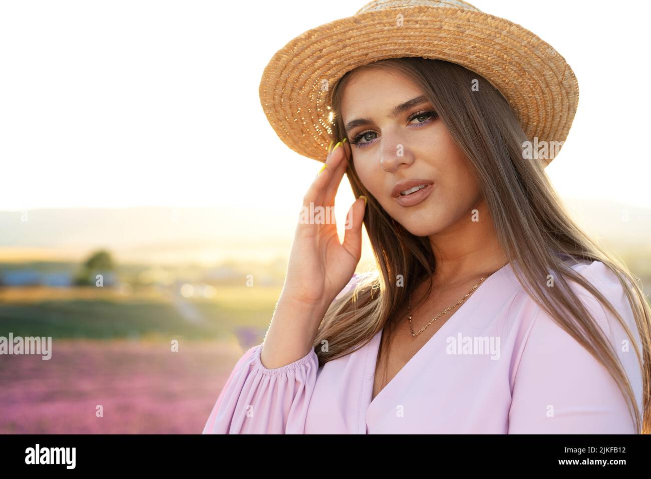 Young woman in a straw hat walking in a lavender field Stock Photo - Alamy