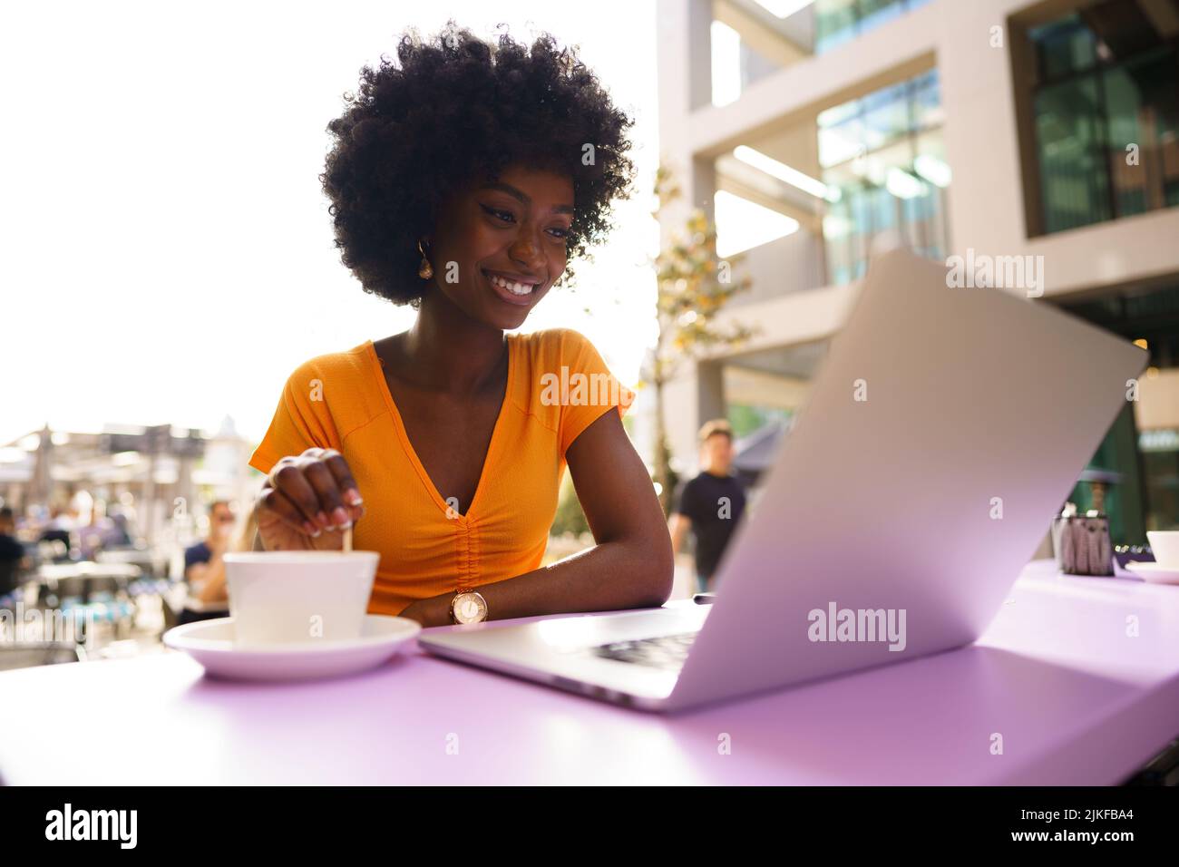 Happy beautiful young black woman using laptop in cafe Stock Photo - Alamy