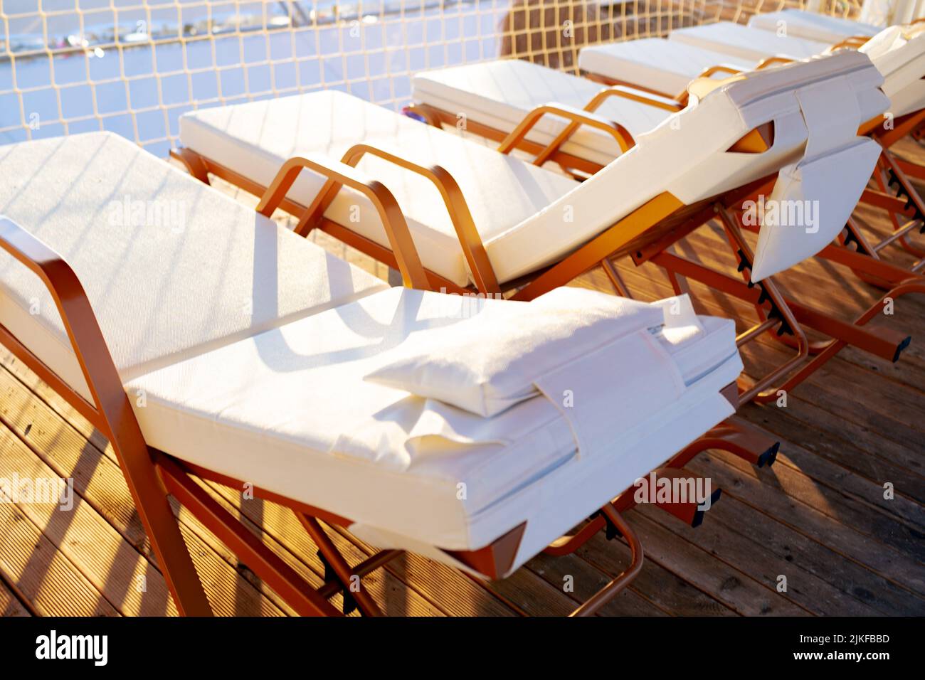 Empty deck chairs with white mattresses in resort hotel Stock Photo - Alamy