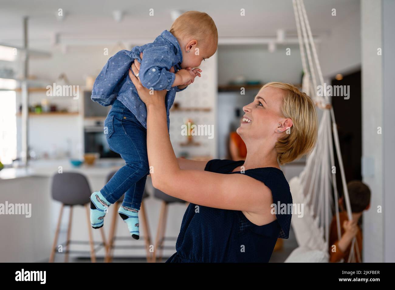 Happy family indoors. Portrait of beautiful mother with cute baby playing smiling together Stock ...