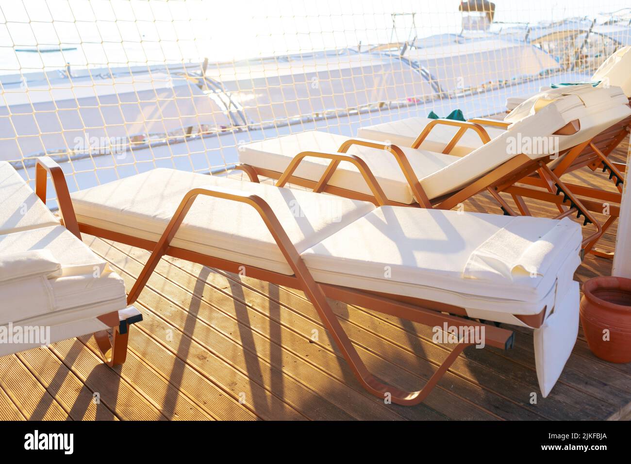 Empty deck chairs with white mattresses in resort hotel Stock Photo - Alamy