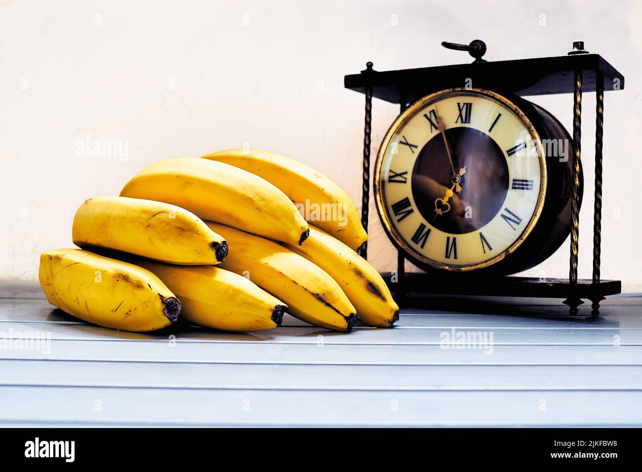 Time for a snack with fresh fruits. Yellow ripe bananas and an old ...