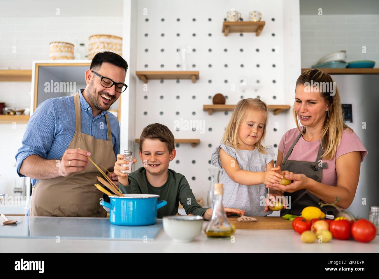 Happy family preparing healthy food together in kitchen Stock Photo - Alamy