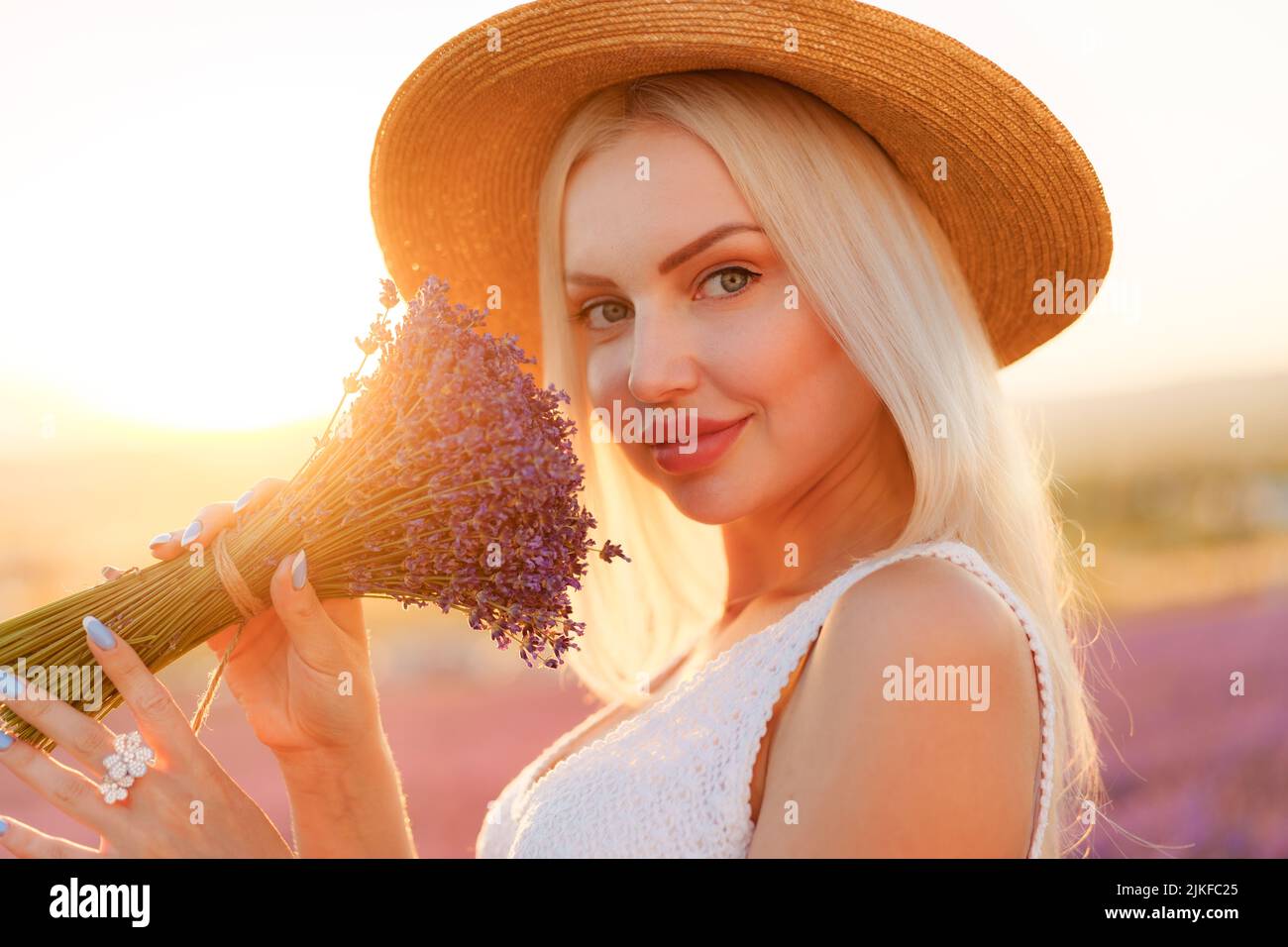 Portrait o charming blonde girl smells lavender flowers in lavender ...
