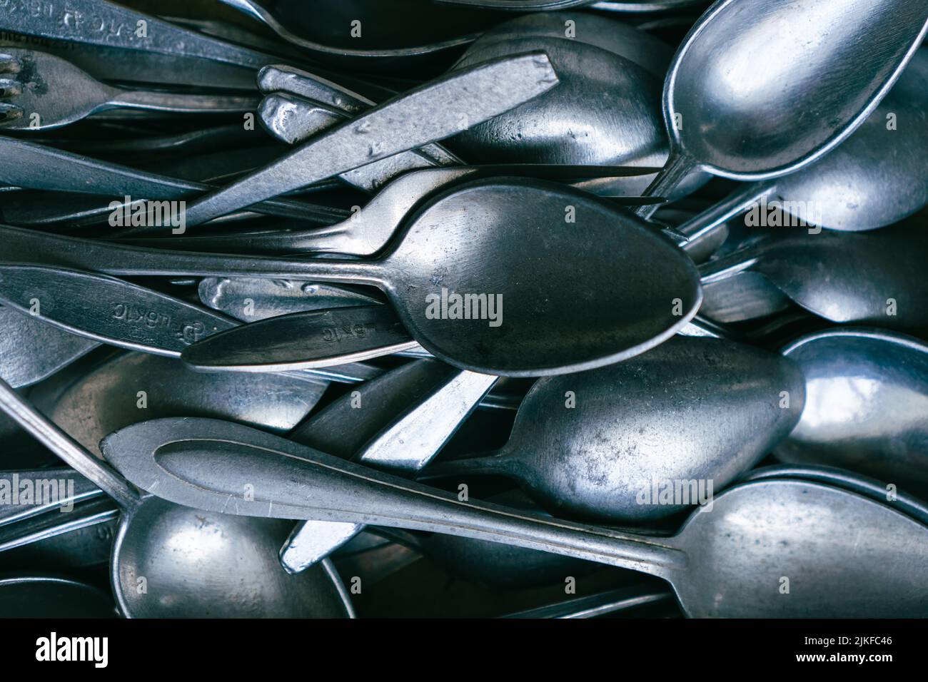Pile of old worn vintage cutlery. Background of aluminium forks and ...
