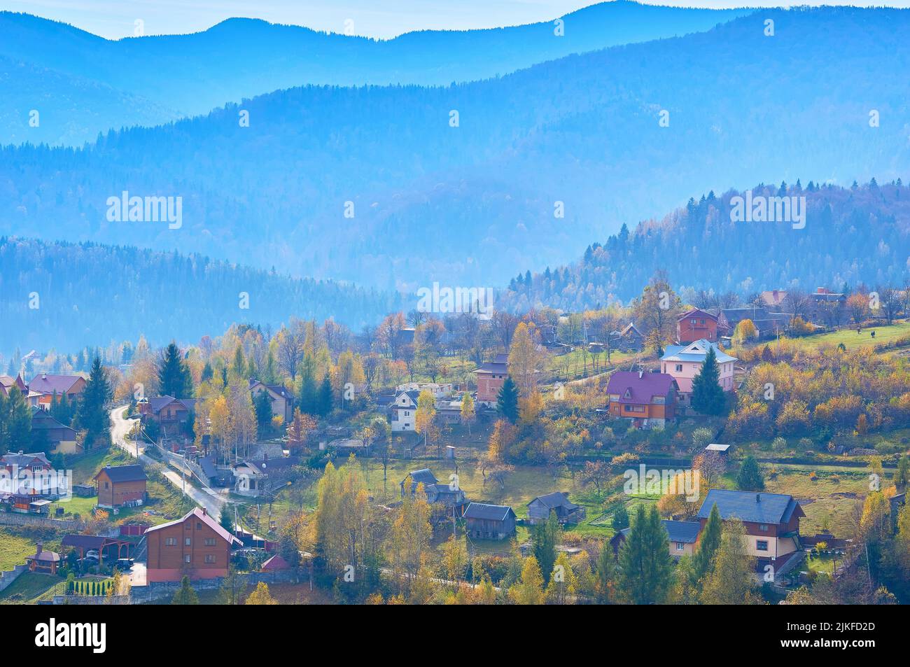 Aerial view of an autumn small village in a valley and mountains in a ...