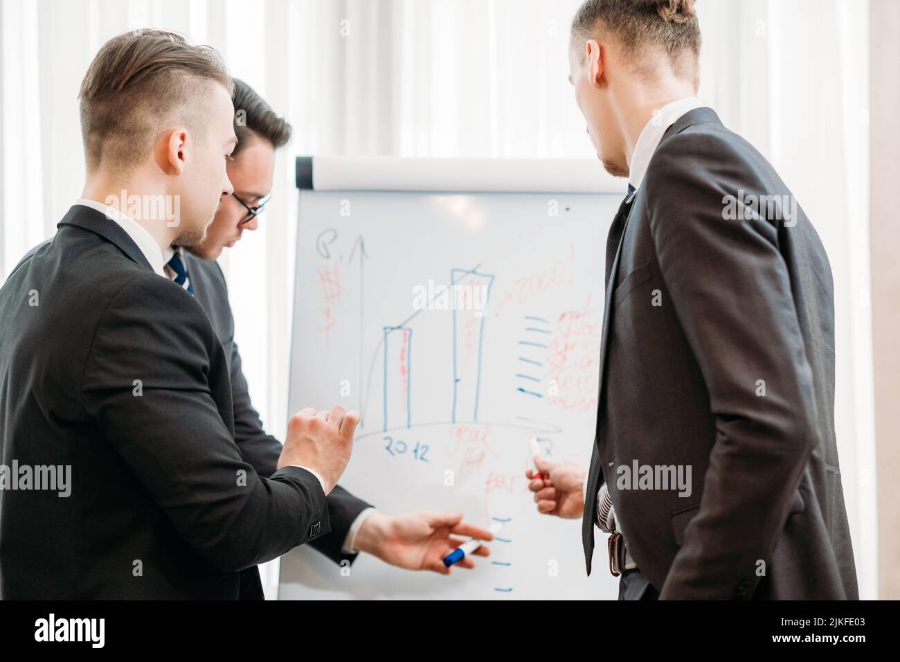teamwork cooperation business men discuss graph Stock Photo - Alamy