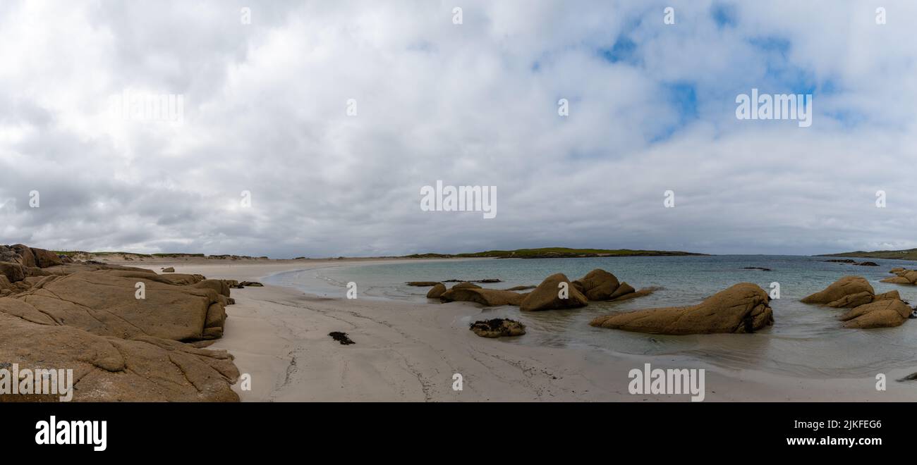 A panorama beach landscape of Dog's Bay with large granite boulders in ...