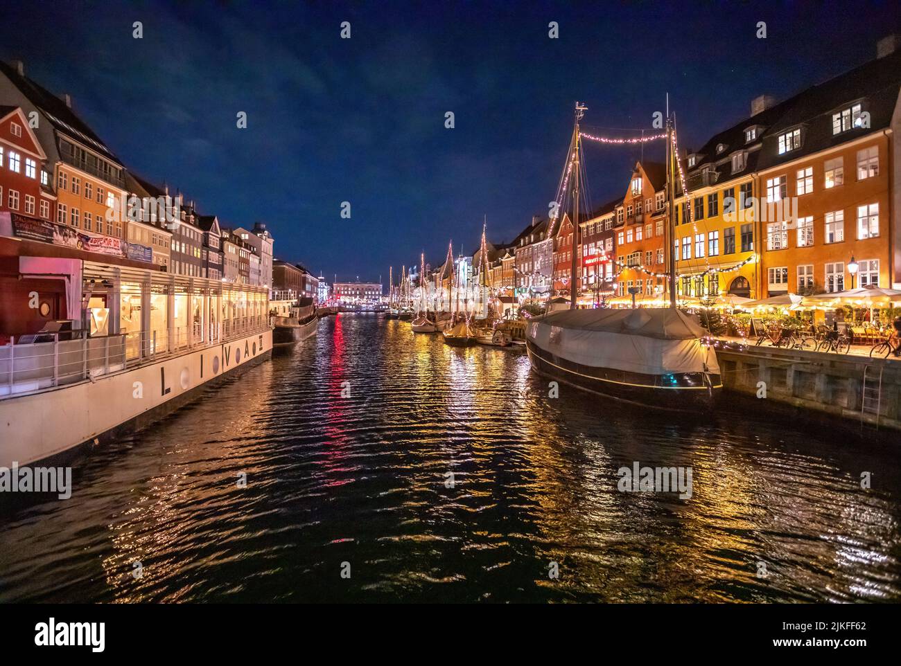 Copenhagen skyline reflections on Nyhavn street at night in Denmark ...