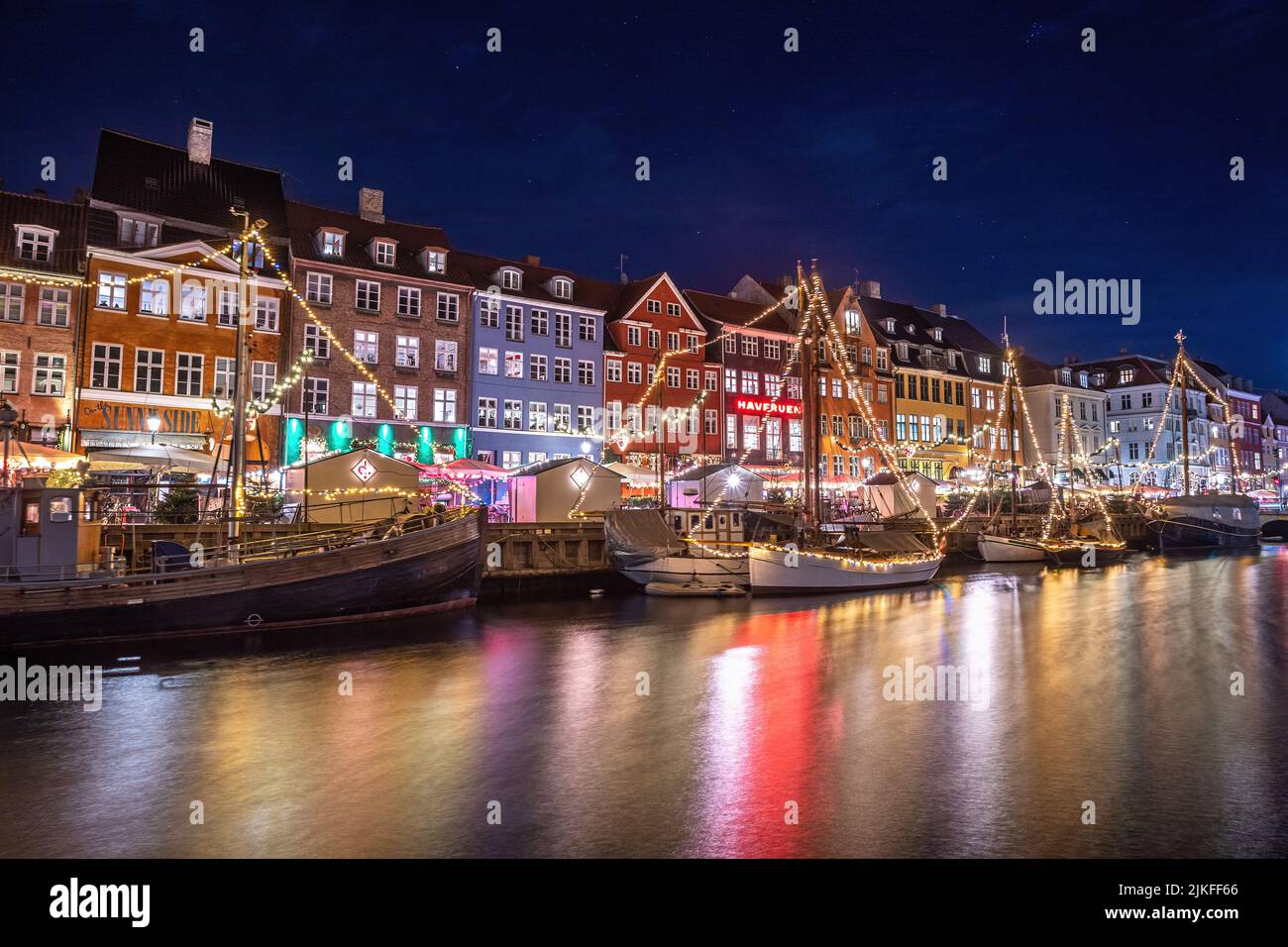 Copenhagen skyline reflections on Nyhavn street at night in Denmark ...