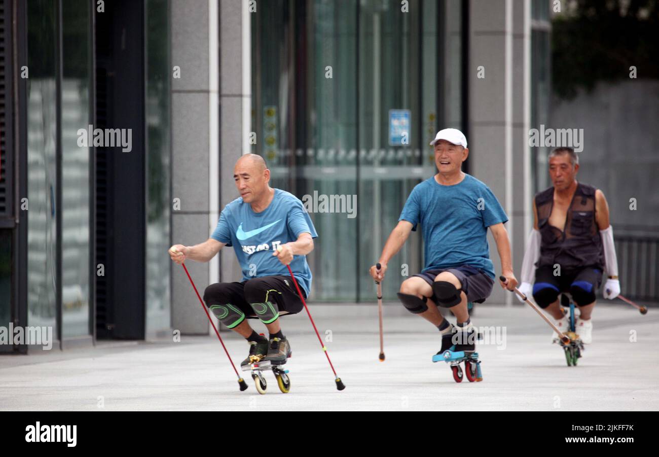 A group of retired elderly people crouch on a special roller skater ...