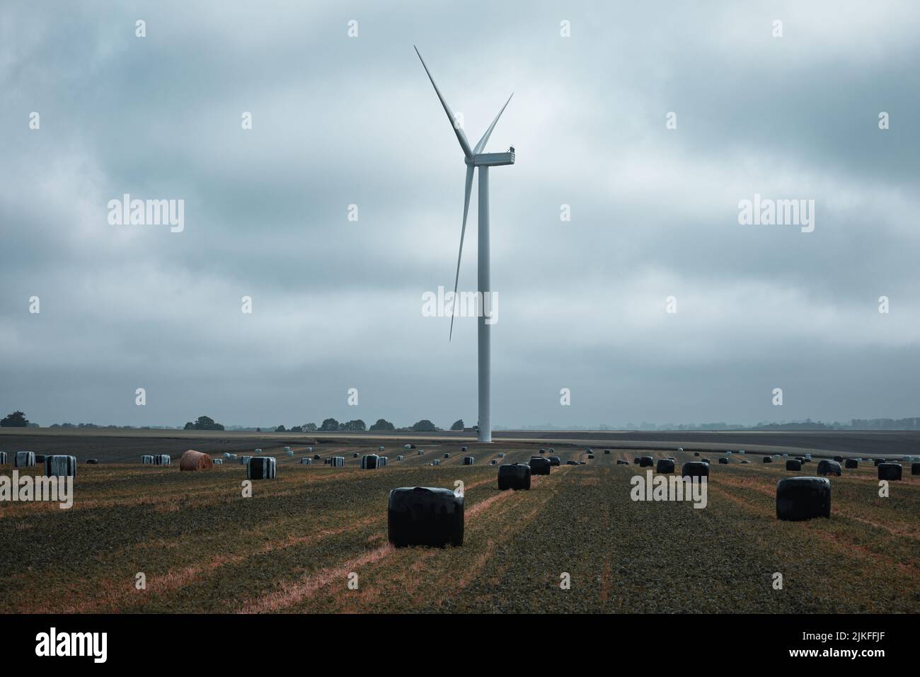 Wind turbine on a agricultural field with hay bale in France Stock ...