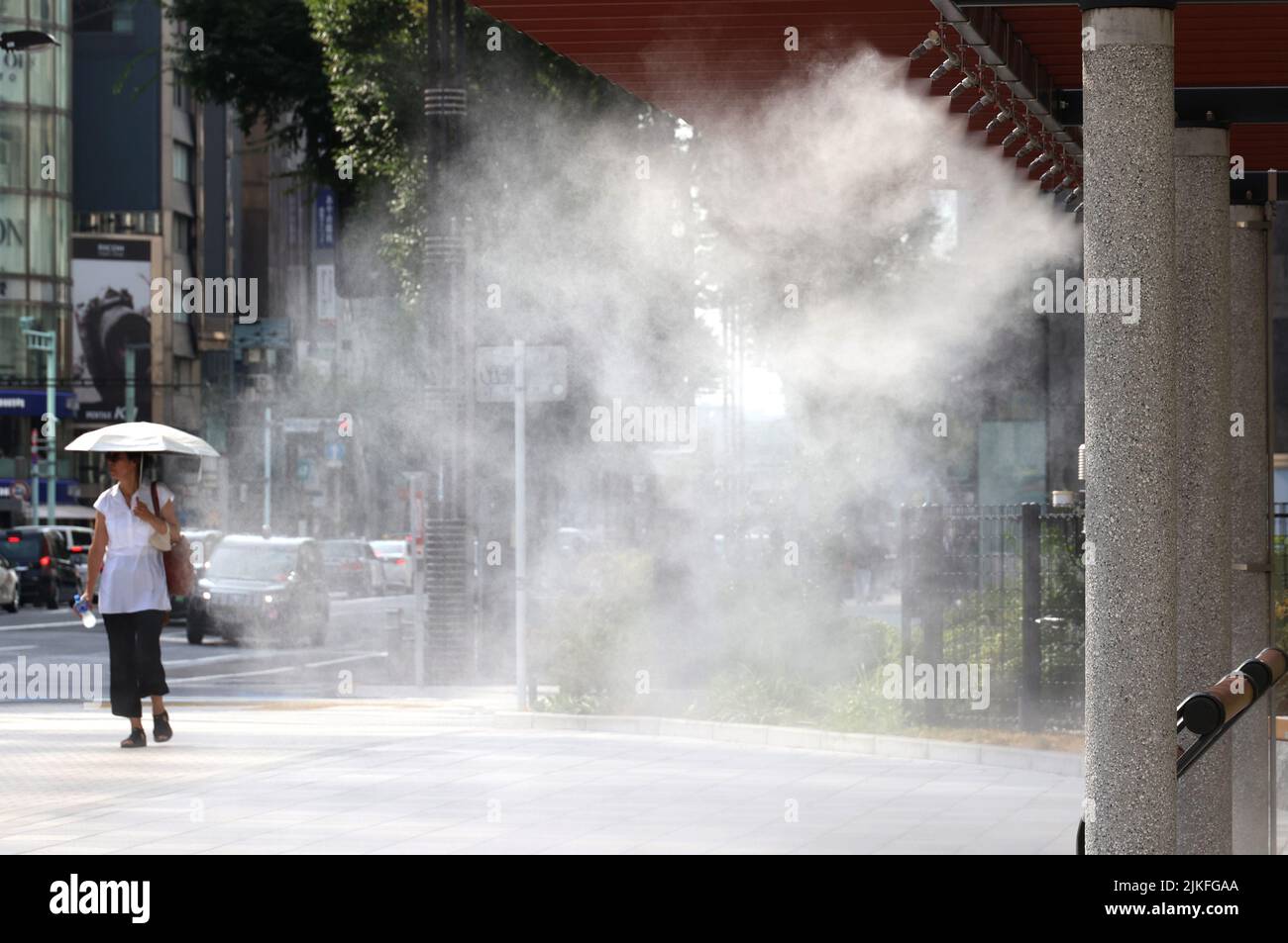 Tokyo, Japan. 2nd Aug, 2022. A pedestrian gets water mist shower to ...