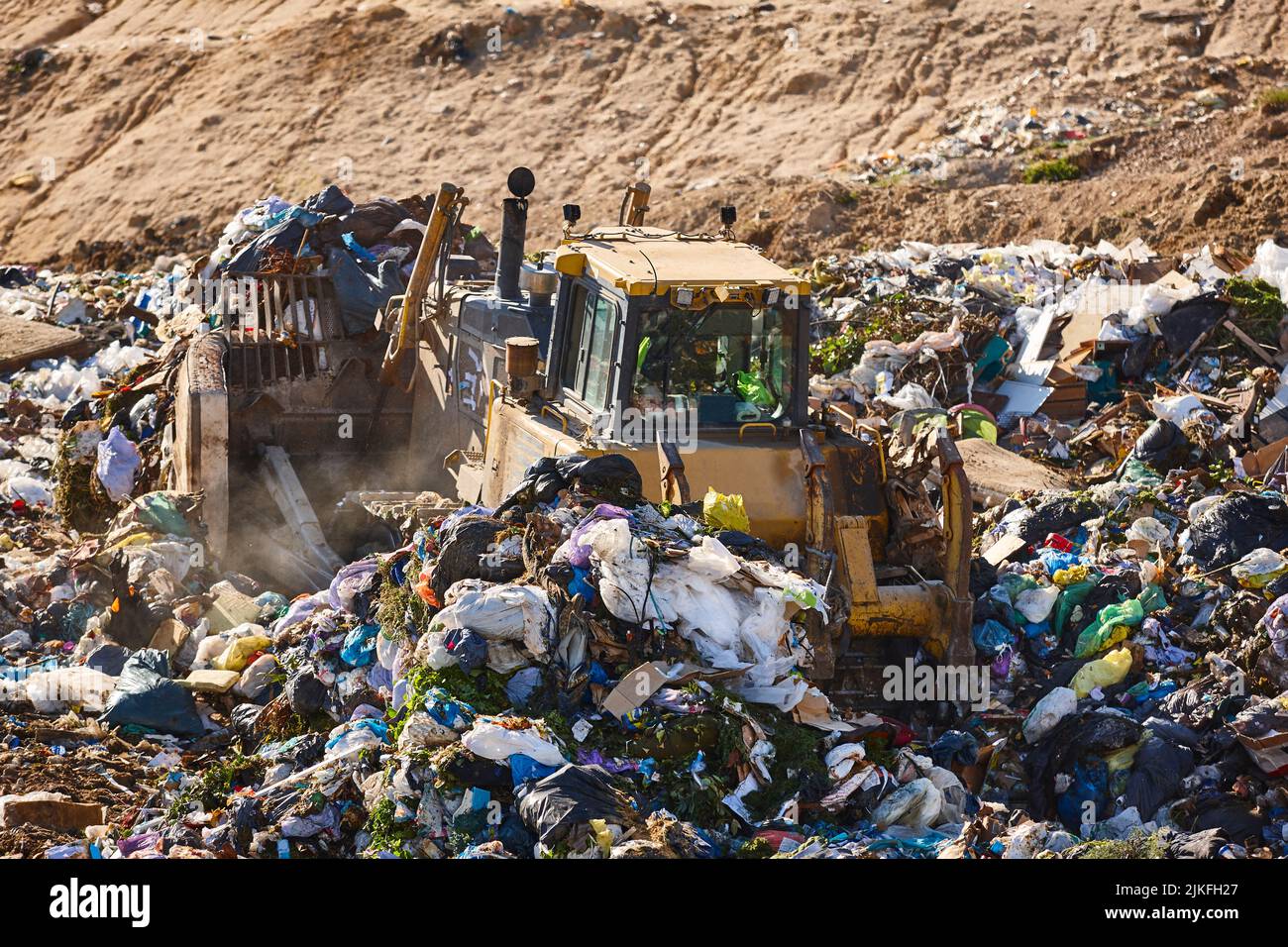 Heavy machinery shredding garbage in an open air landfill. Waste Stock ...