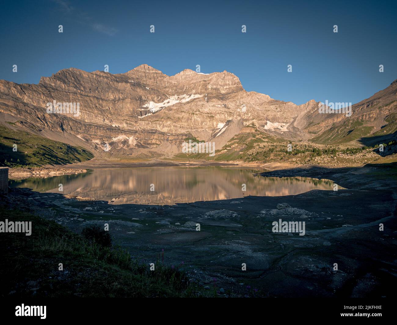 Beautiful Alpine mountain valley. Pine trees line a steep mountain side ...