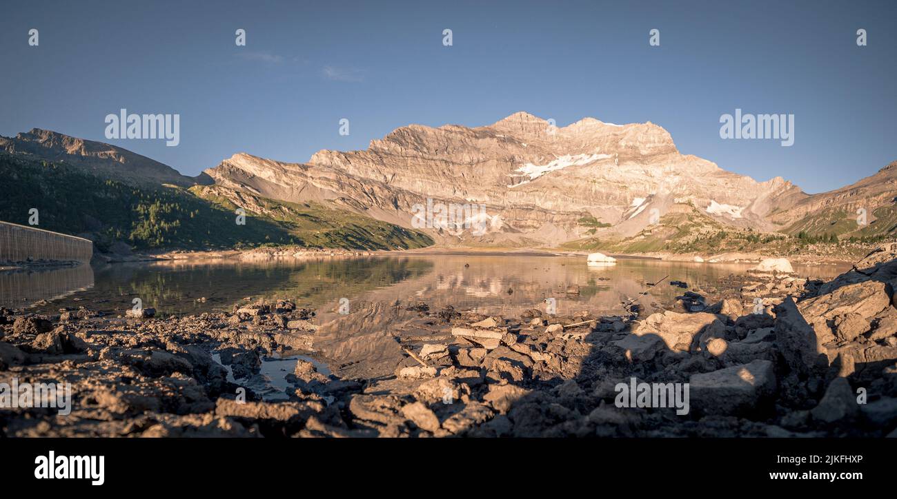 Beautiful Alpine mountain valley. Pine trees line a steep mountain side ...
