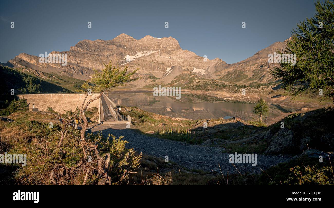 Beautiful Alpine mountain valley. Pine trees line a steep mountain side ...