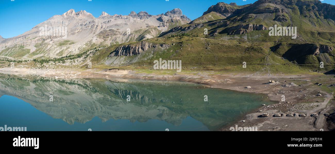Beautiful Alpine mountain valley. Pine trees line a steep mountain side ...