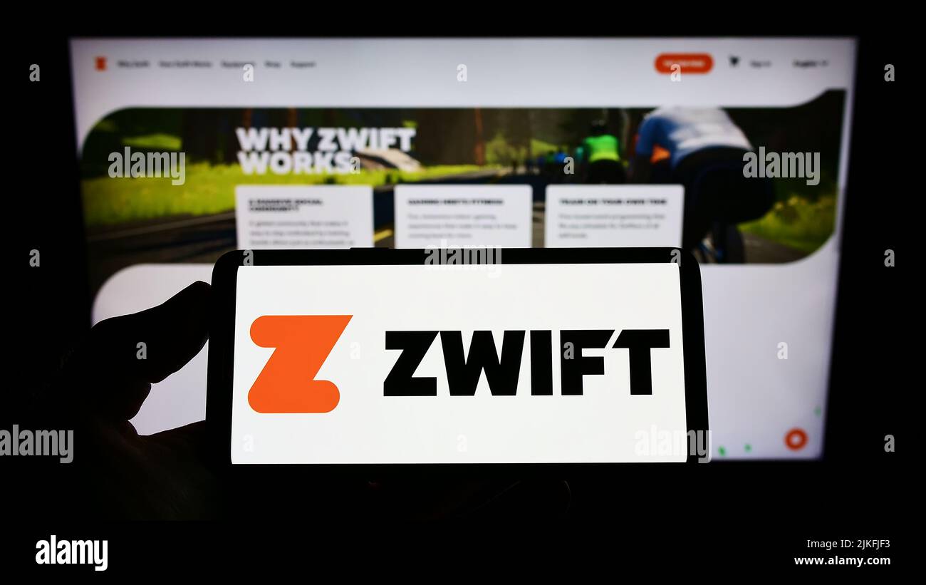 Person holding smartphone with logo of US fitness gaming company Zwift ...
