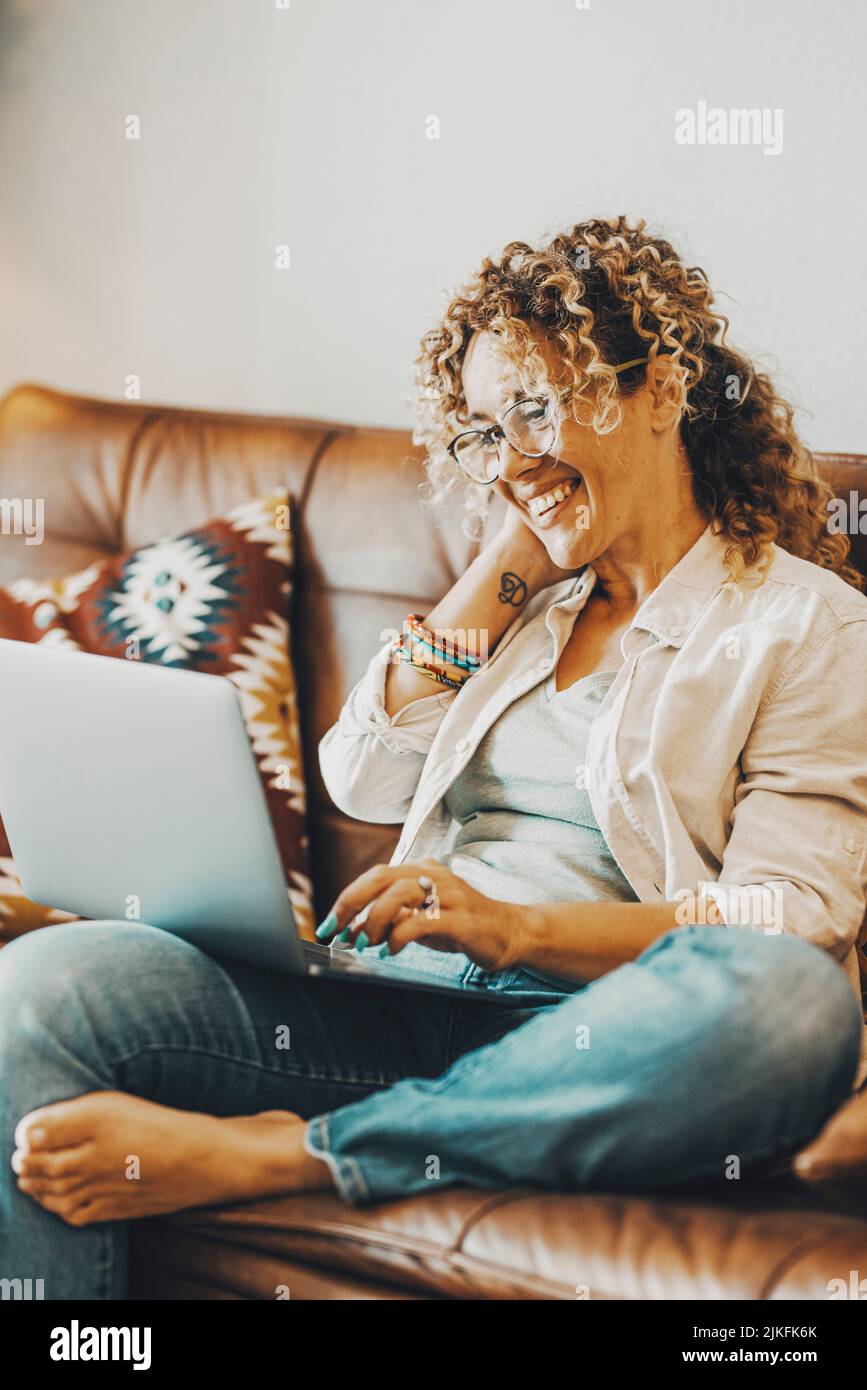 Happy woman using laptop at home to video call friends or parents ...