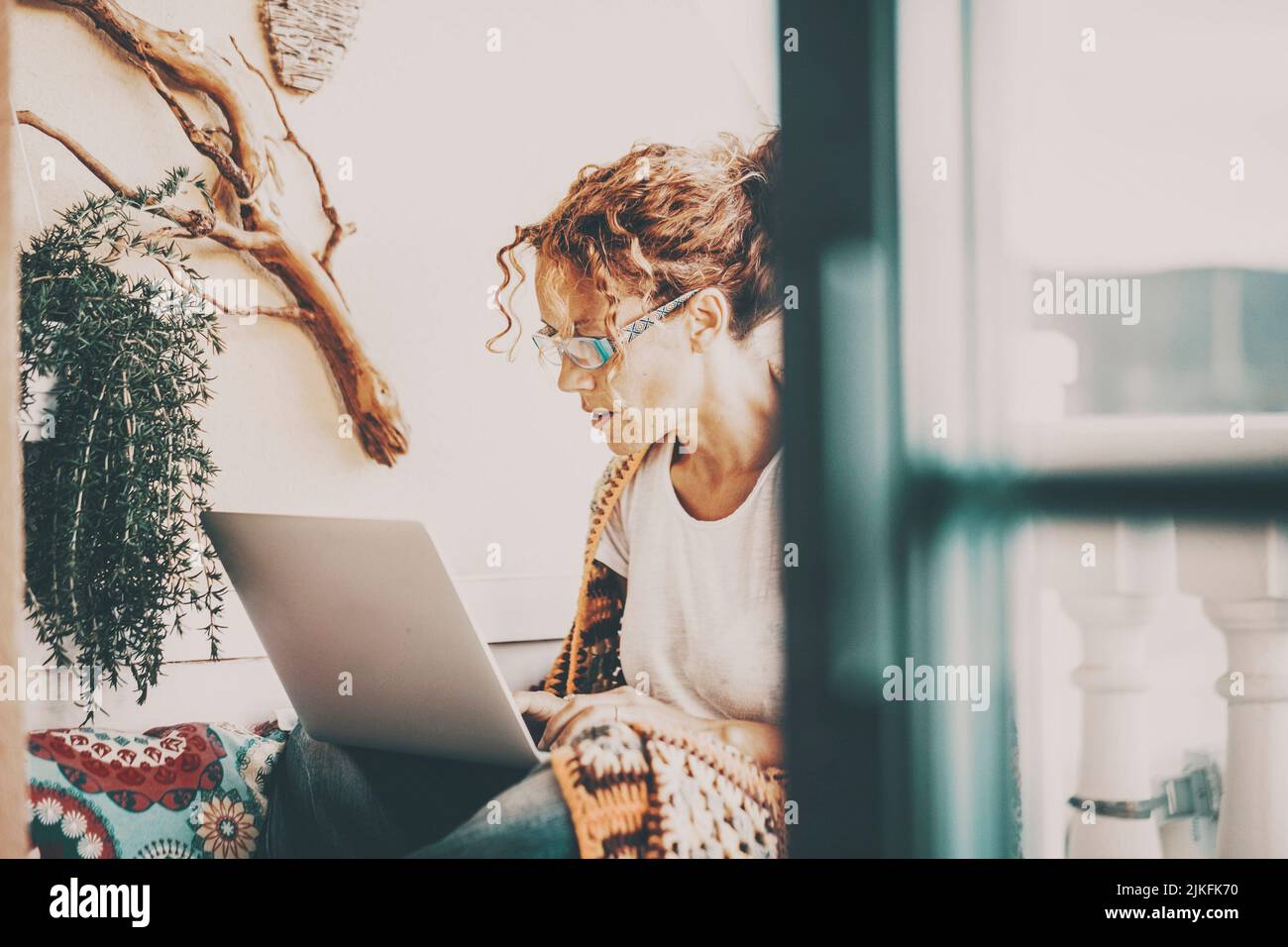 One busy woman working and using laptop outdoor at home sitting in the ...