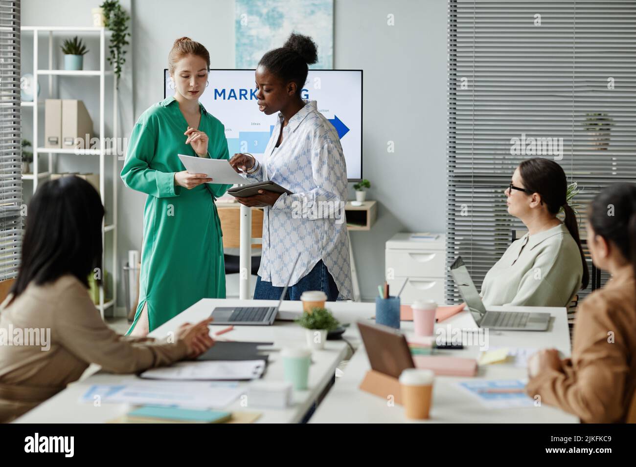 Group of businesswomen discussing business plans together during ...