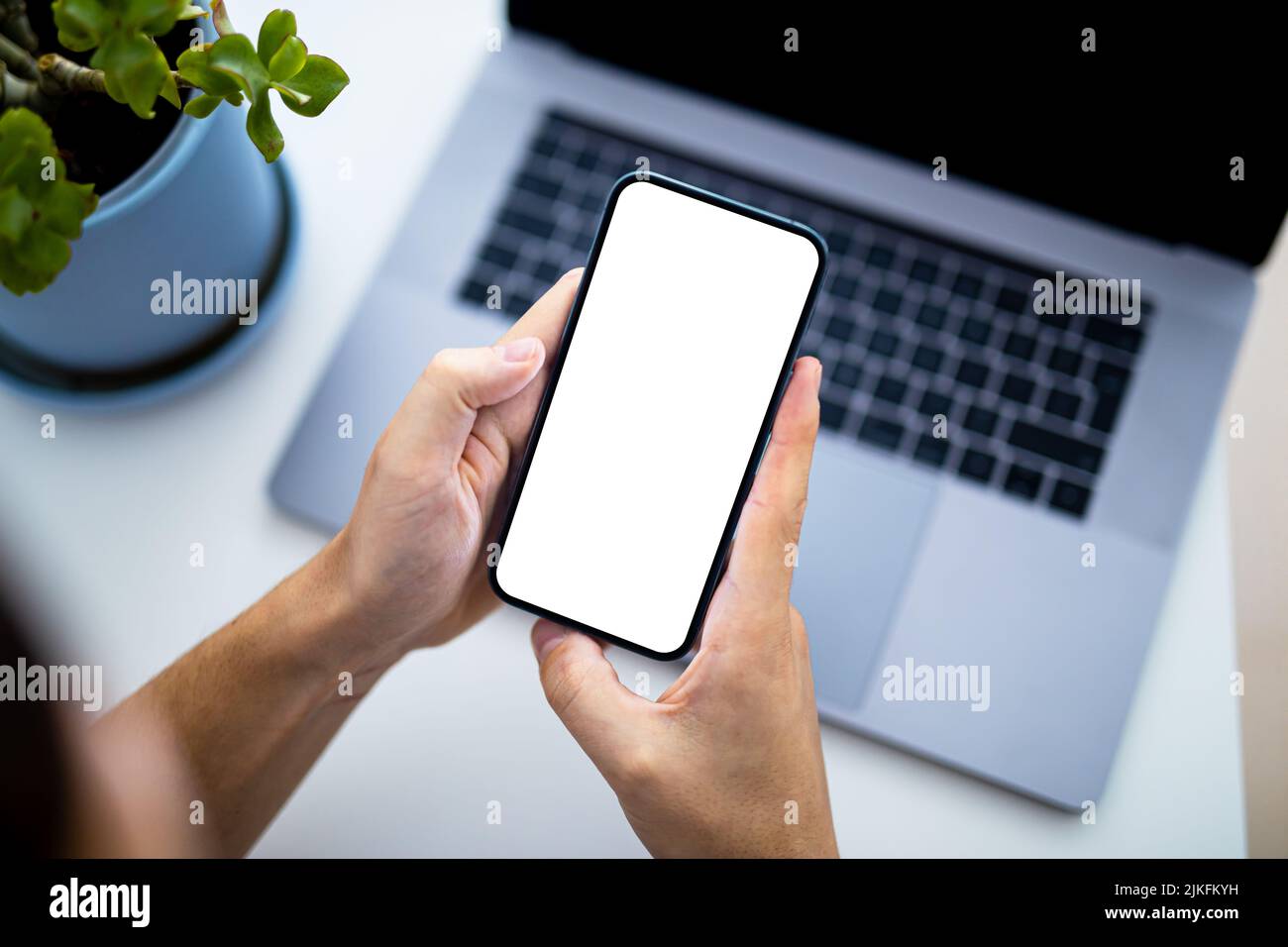 Man using smartphone blank screen frameless modern - top view, laptop ...