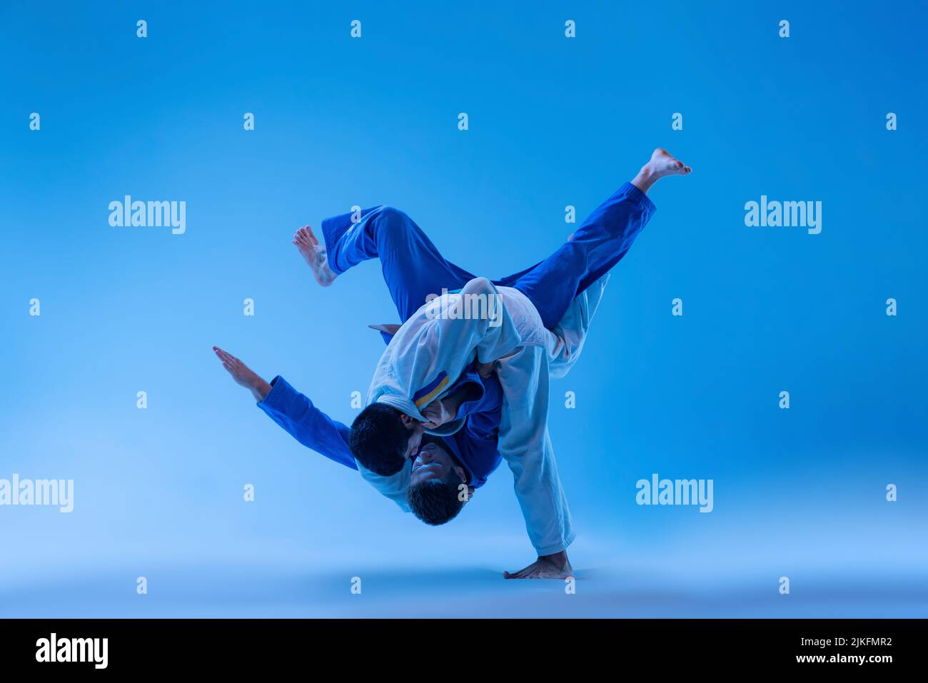 Dynamic portrait of professional judo athletes training isolated over ...