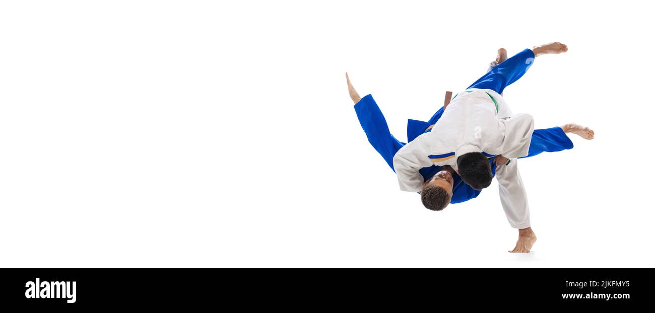 Studio shot of two men, professional judo athletes training isolated ...