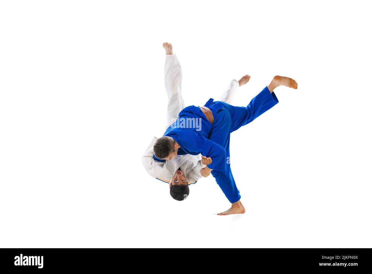 Studio shot of two men, professional judo athletes training isolated ...