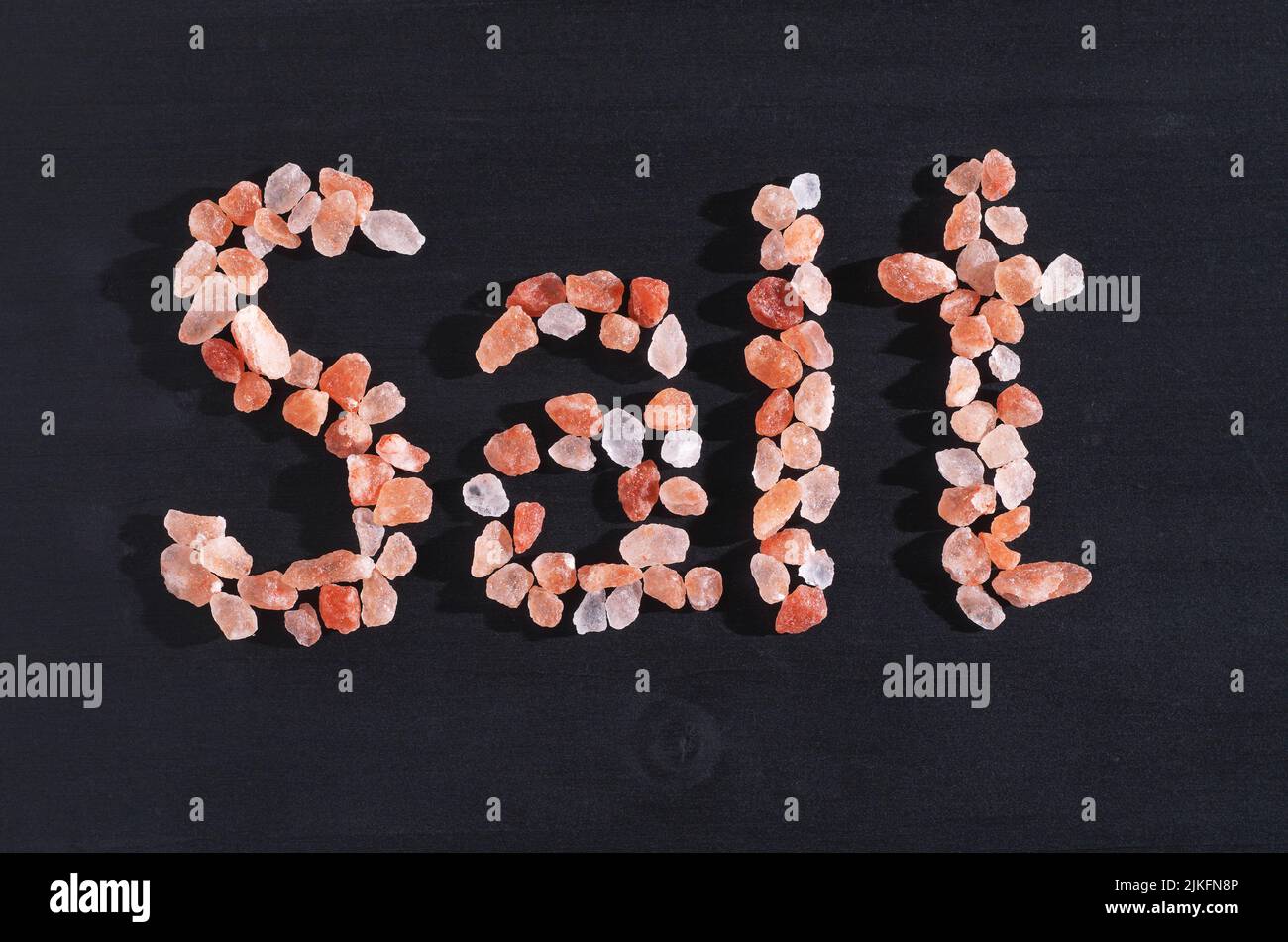 Himalayan pink salt in word shape on black background, top view Stock ...
