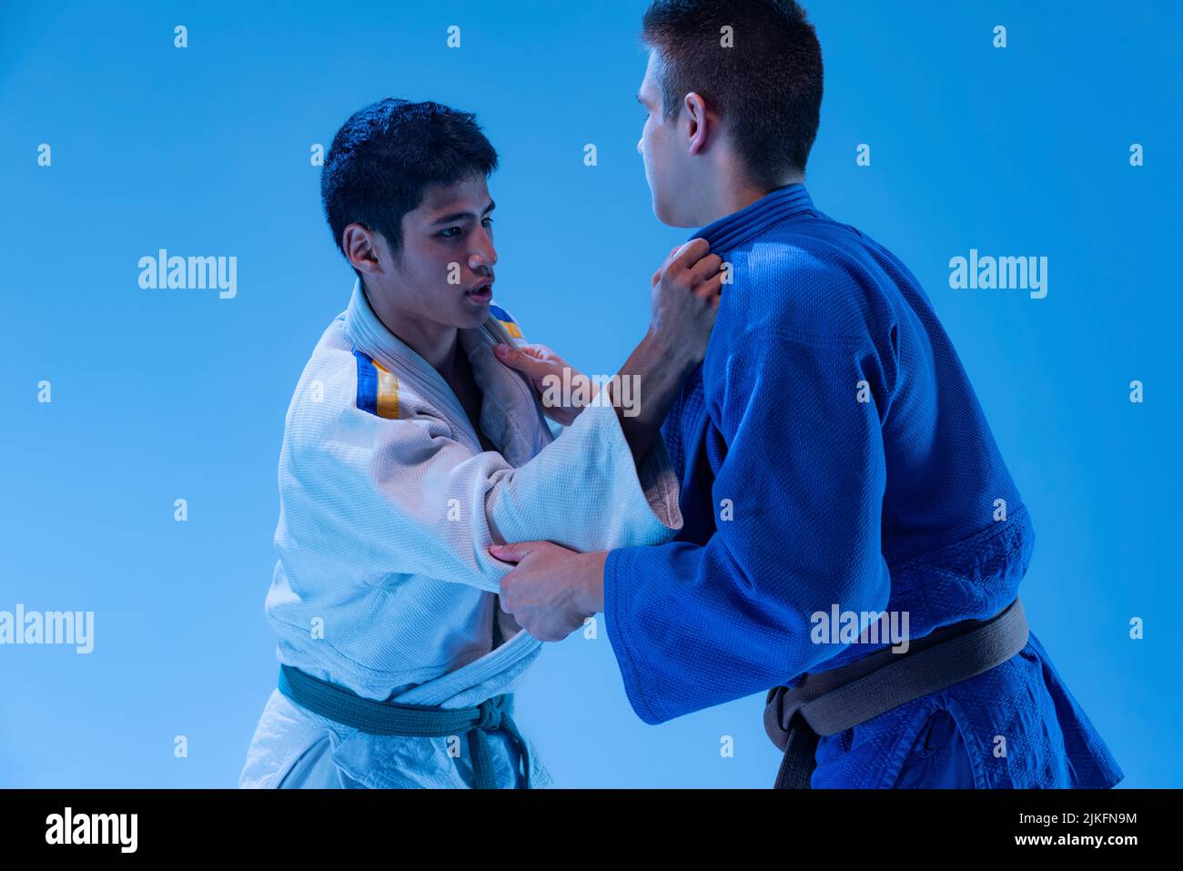 Portrait of two professional judo athletes training, fighting isolated ...