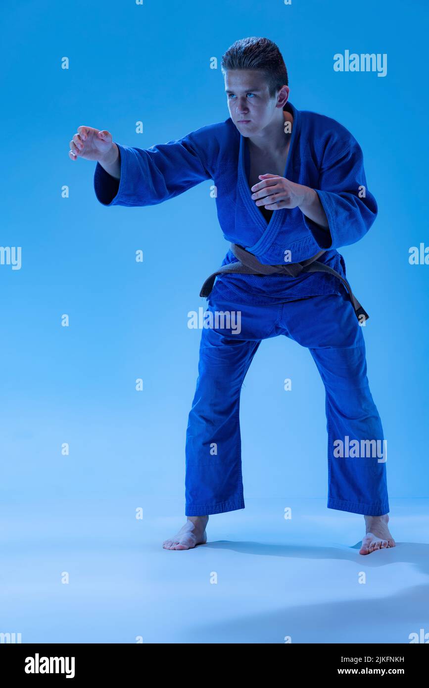 Portrait of young sportive man posing in position to punch isolated ...